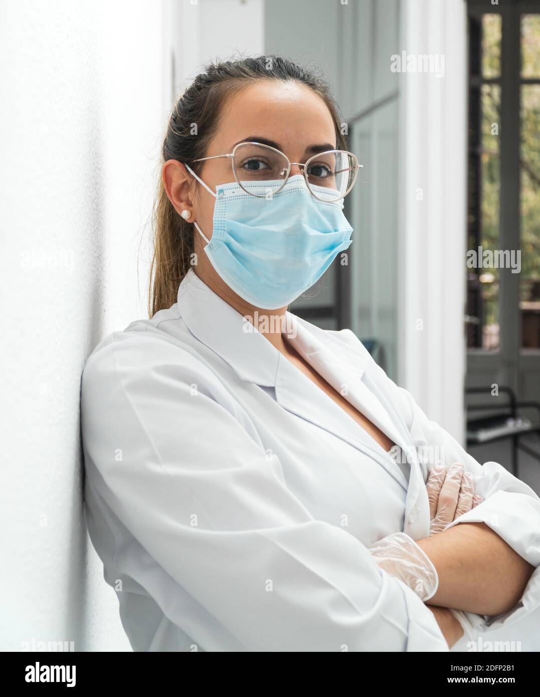 Portrait of a young doctor wearing a mask The doctor is leaning against ...