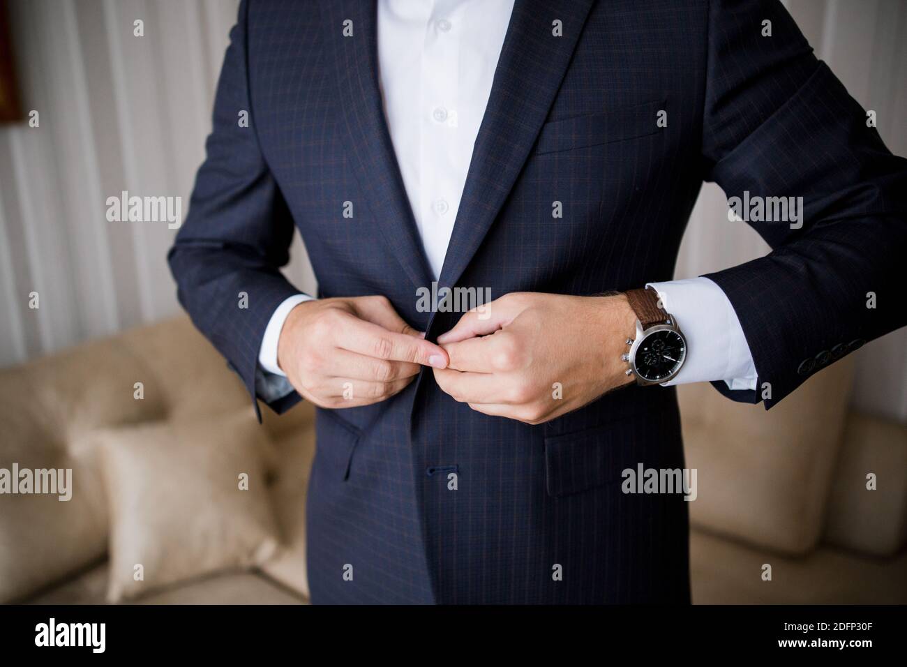 man in a suit buttons the button of his jacket Stock Photo - Alamy