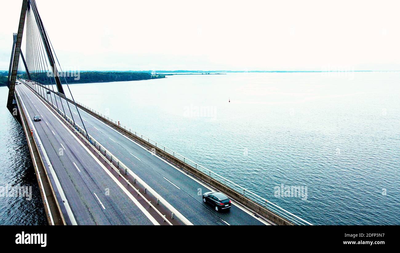 Large highway bridge spanning over a bay, with cars and trucks driving ...