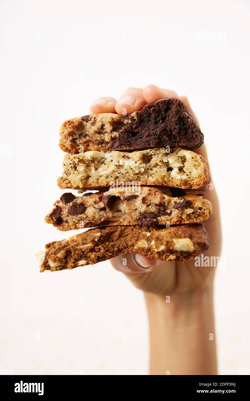 Hand holding cookie stack on white background Stock Photo - Alamy