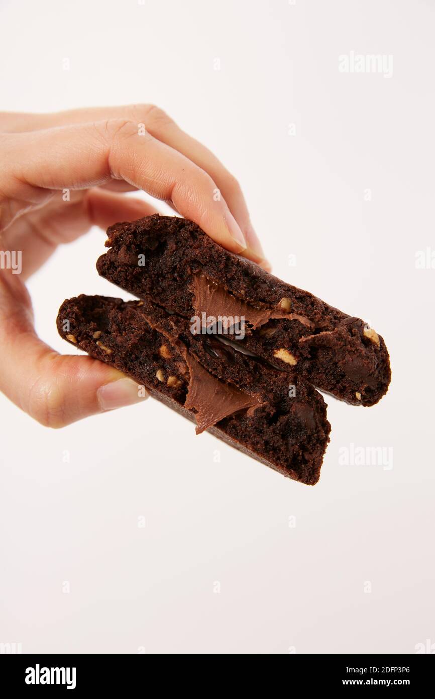 Hand holding chocolate cookies with liquid center Stock Photo - Alamy