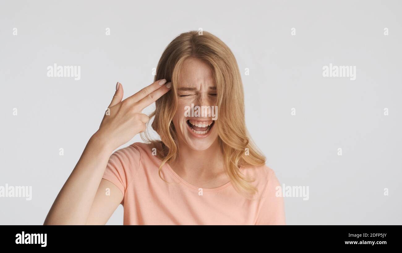 Upset screaming girl showing gun sign over white background. Gun Stock ...