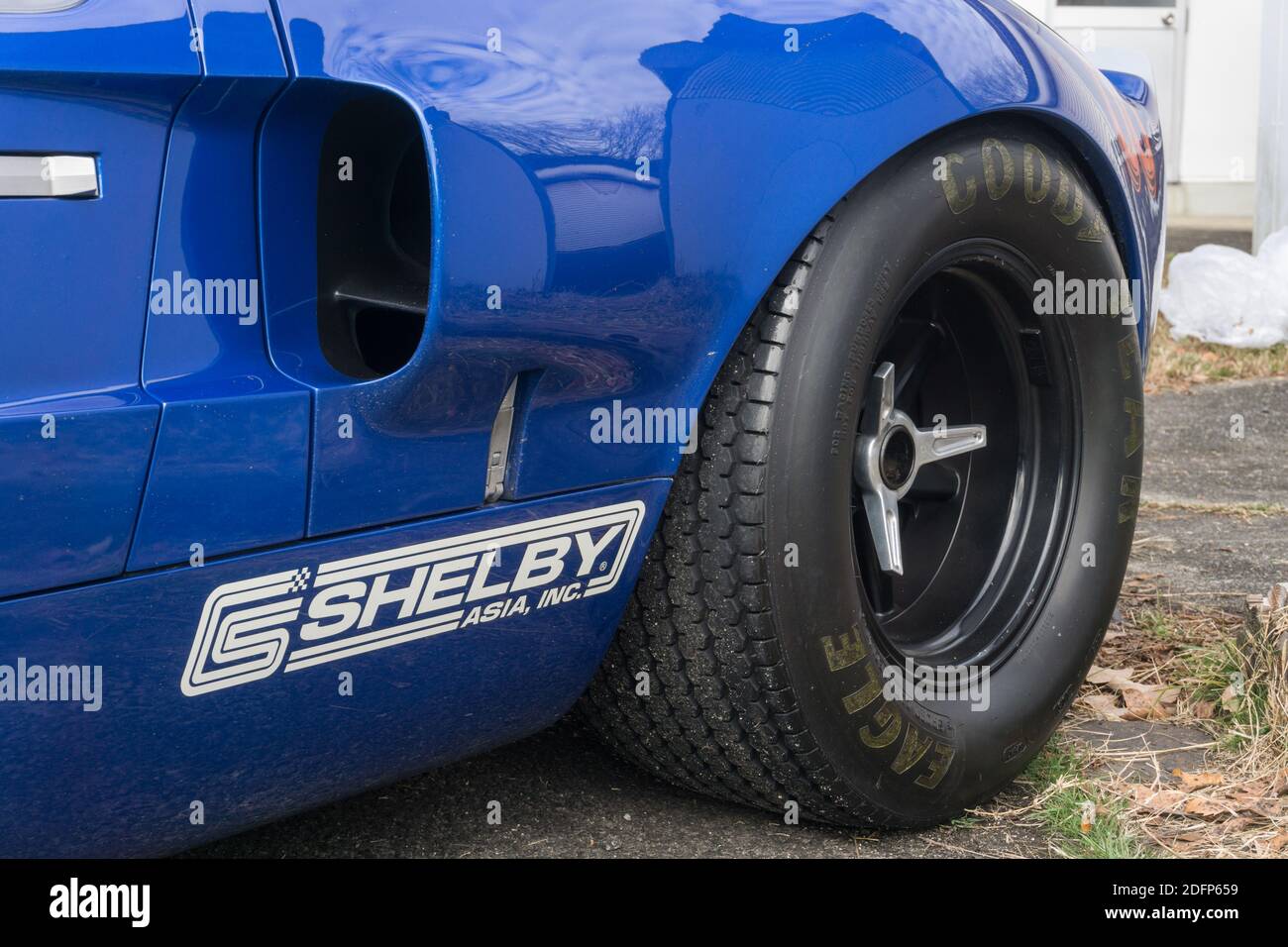 Close up detail of the rear wheel and arch of a metallic blue and white ...
