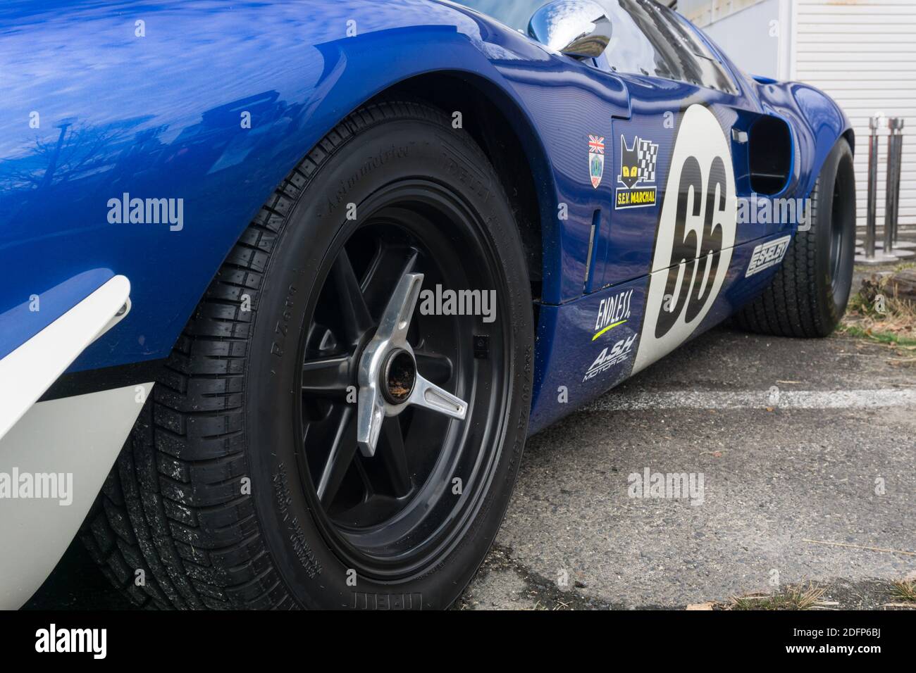 Close up detail of the front wheel and arch of a metallic blue and ...