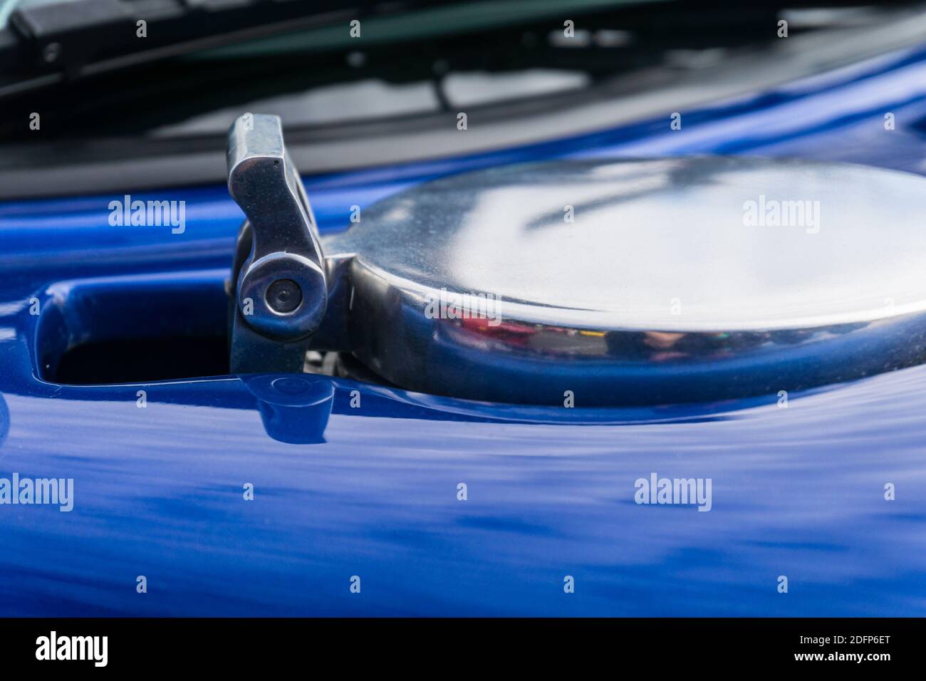 Close up detail of the chrome fuel filler cap on a metallic blue and ...