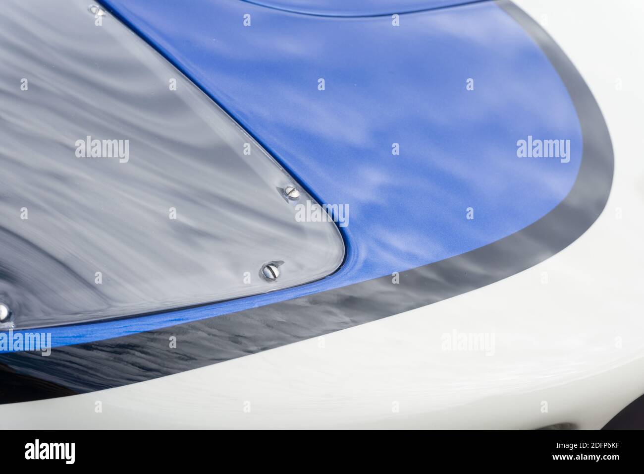 Close up detail of the bonnet and headlight on a metallic blue and ...