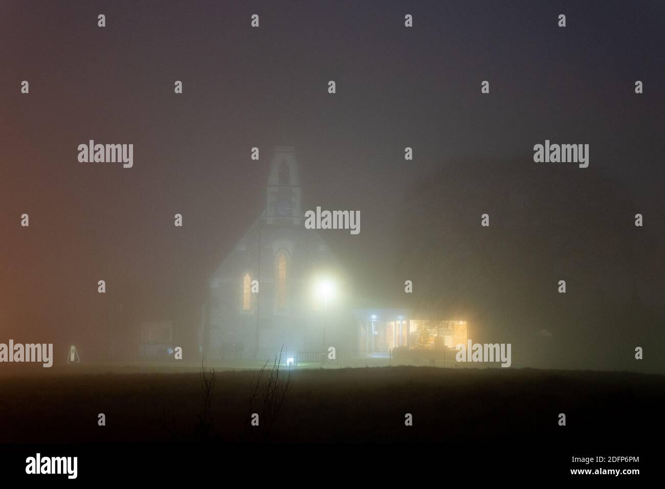 A church lit up on an atmospheric foggy, winters night Stock Photo - Alamy