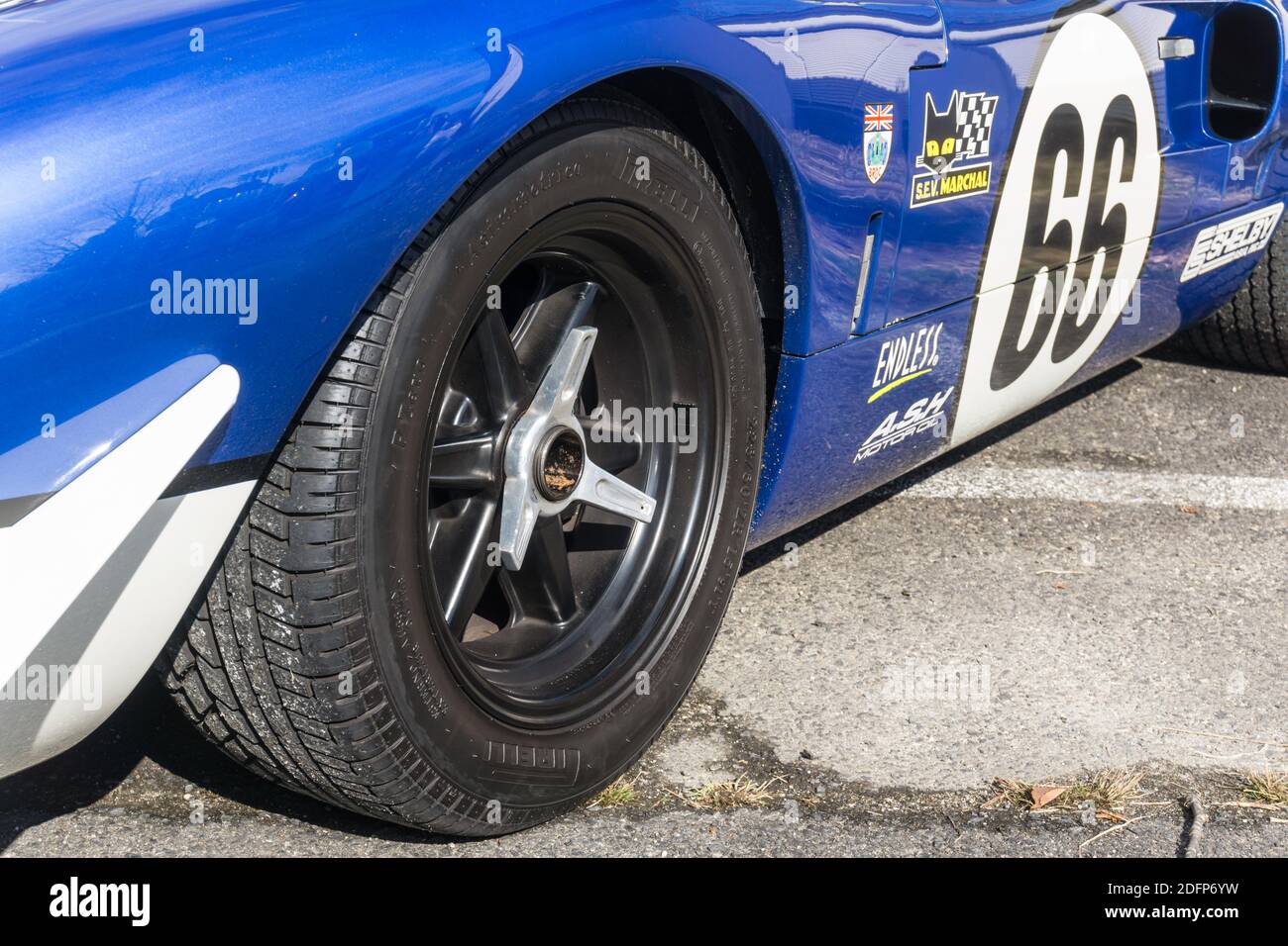 Close up detail of the black alloy wheel of a metallic blue and white ...