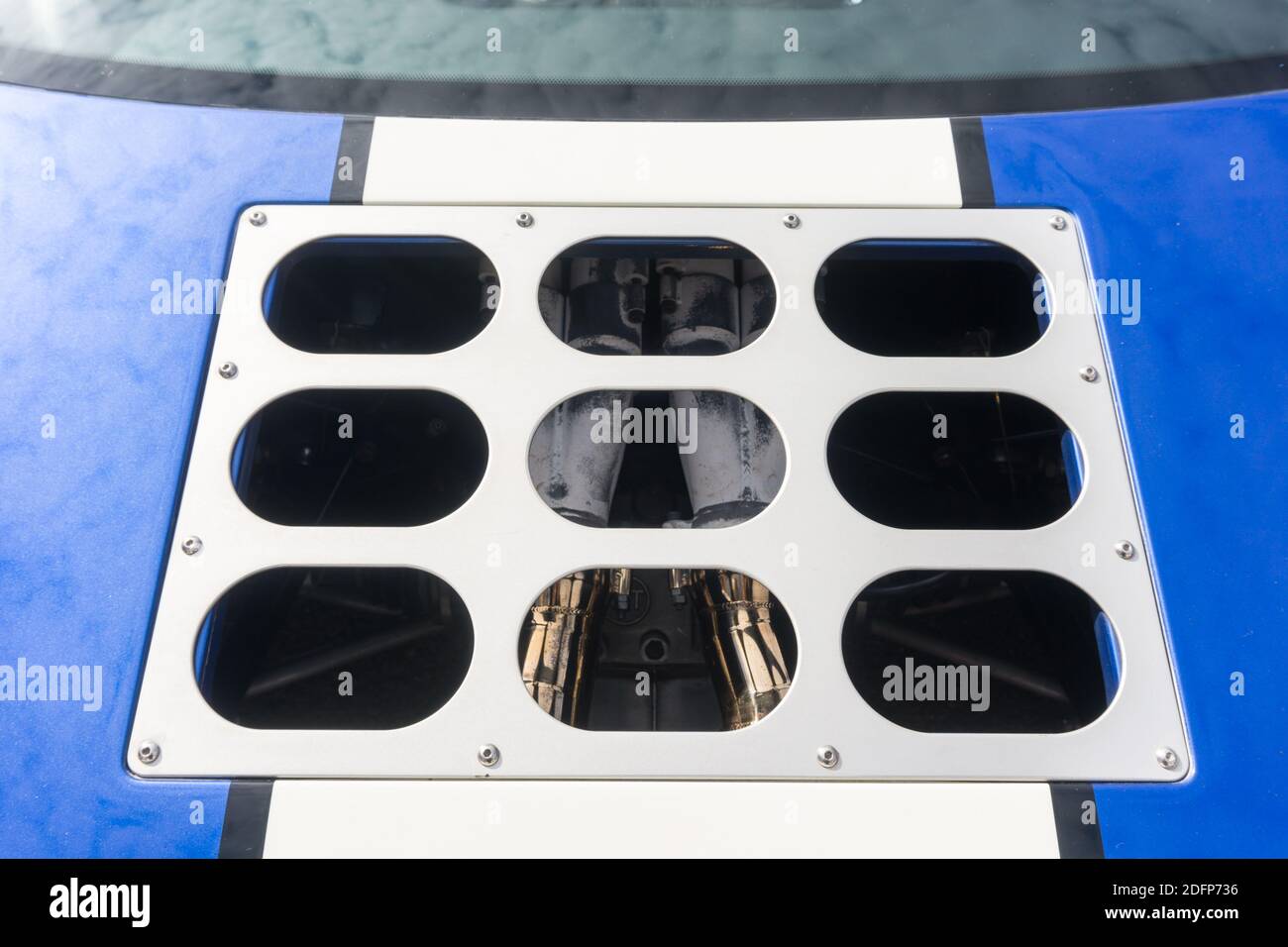 Close up detail of a vent over the exhaust manifold of a metallic blue ...