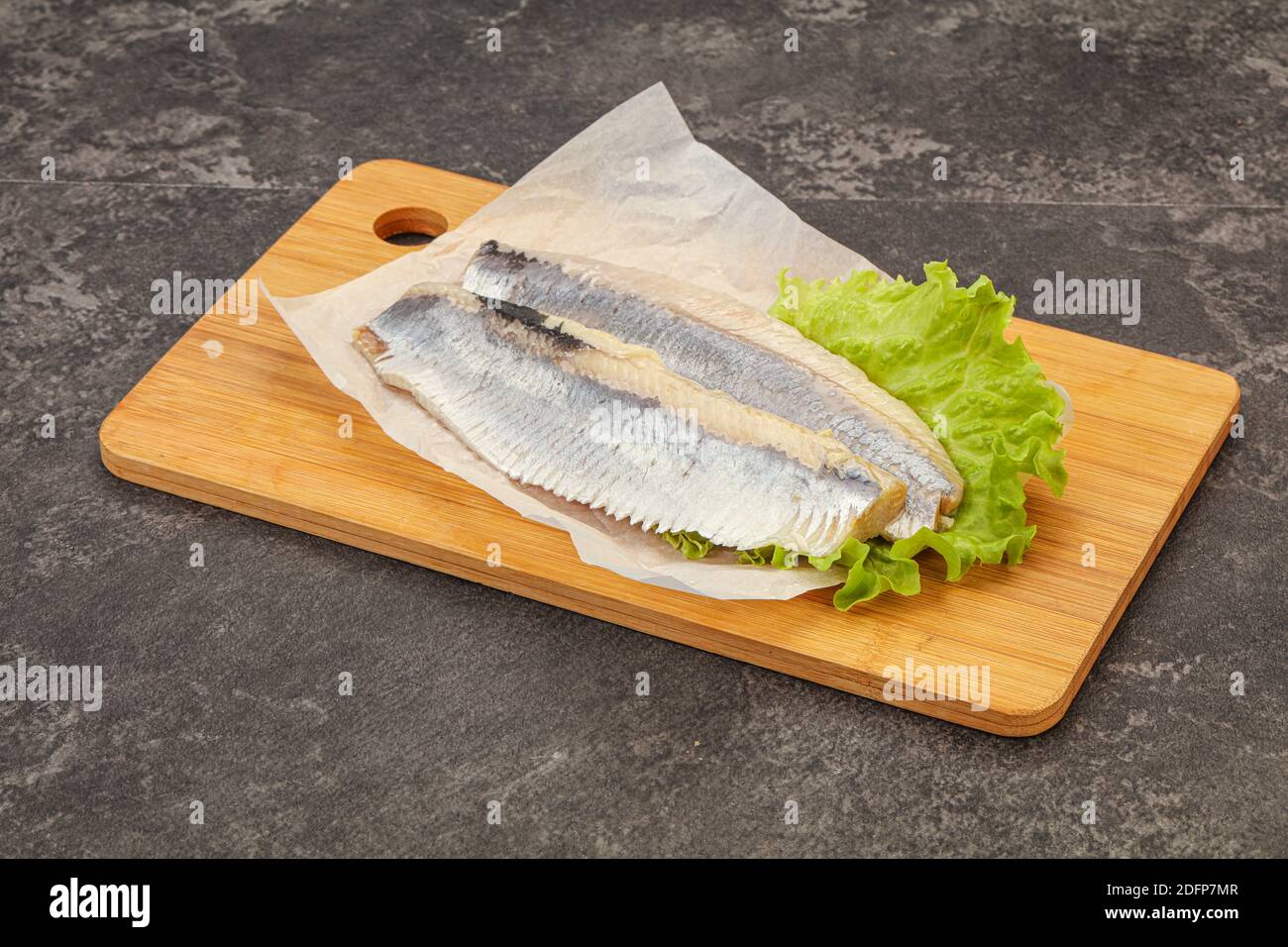 Herring fillet with salad leaves over board Stock Photo - Alamy