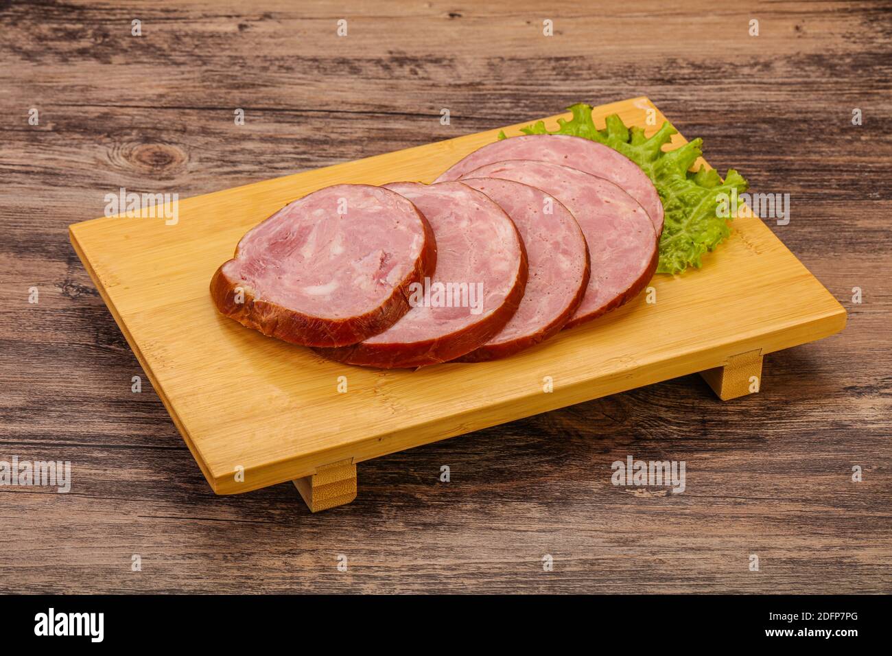 Slices of pork meat ham over wooden board Stock Photo - Alamy