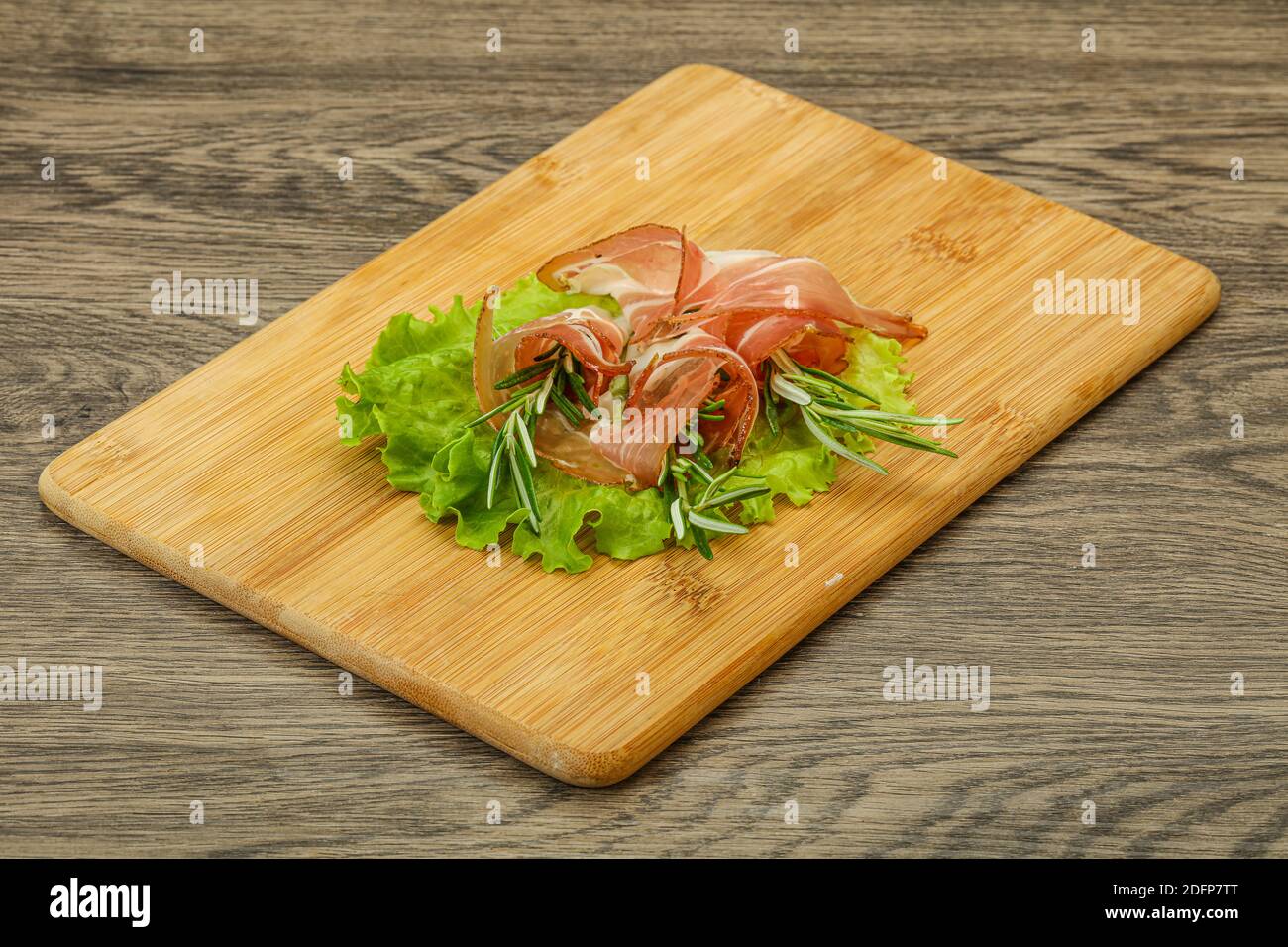 Sliced pork Jamon meat with rosemary Stock Photo - Alamy