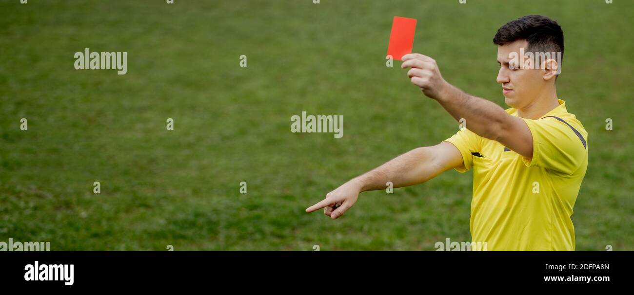Angry football referee showing a red card and pointing with his hand on ...