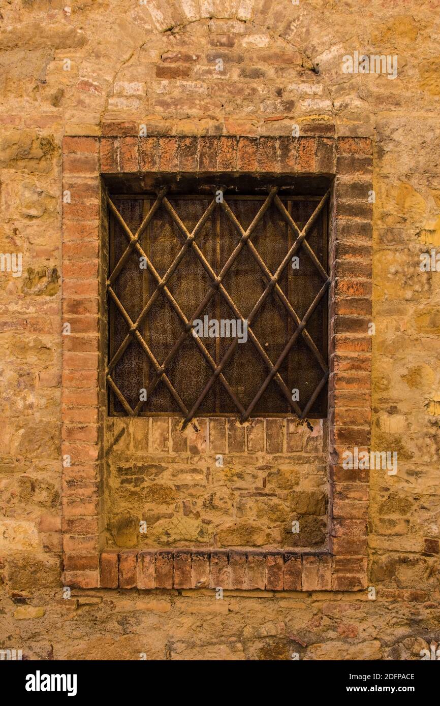 A partially bricked-in window in the historic medieval village of San ...
