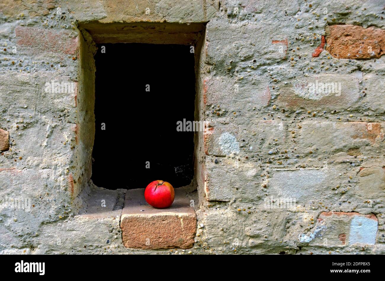 red apple lying in an opening of an unplastered brick wall Stock Photo ...