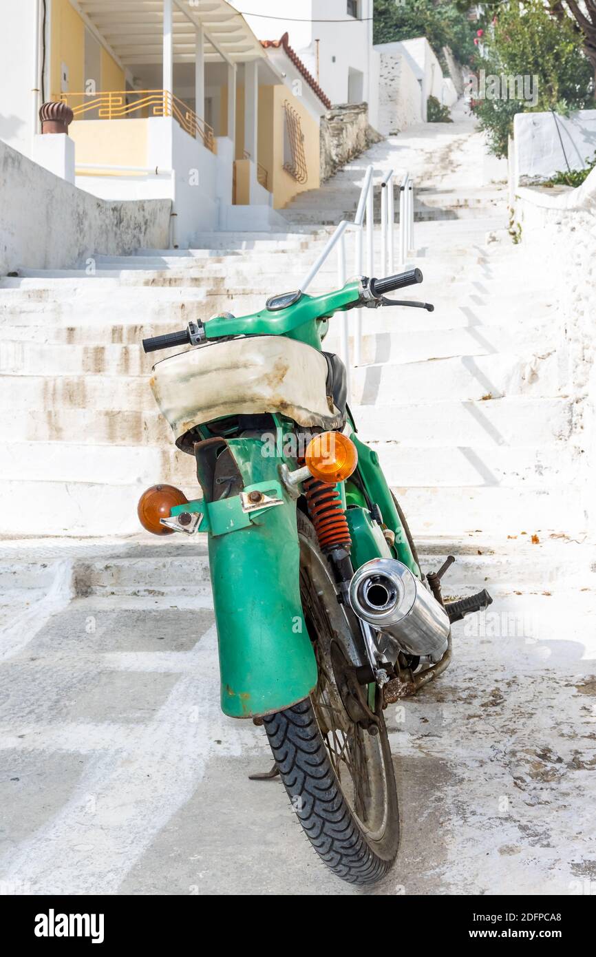 A vertical shot of a green moped at the bottom of a staircase in the ...
