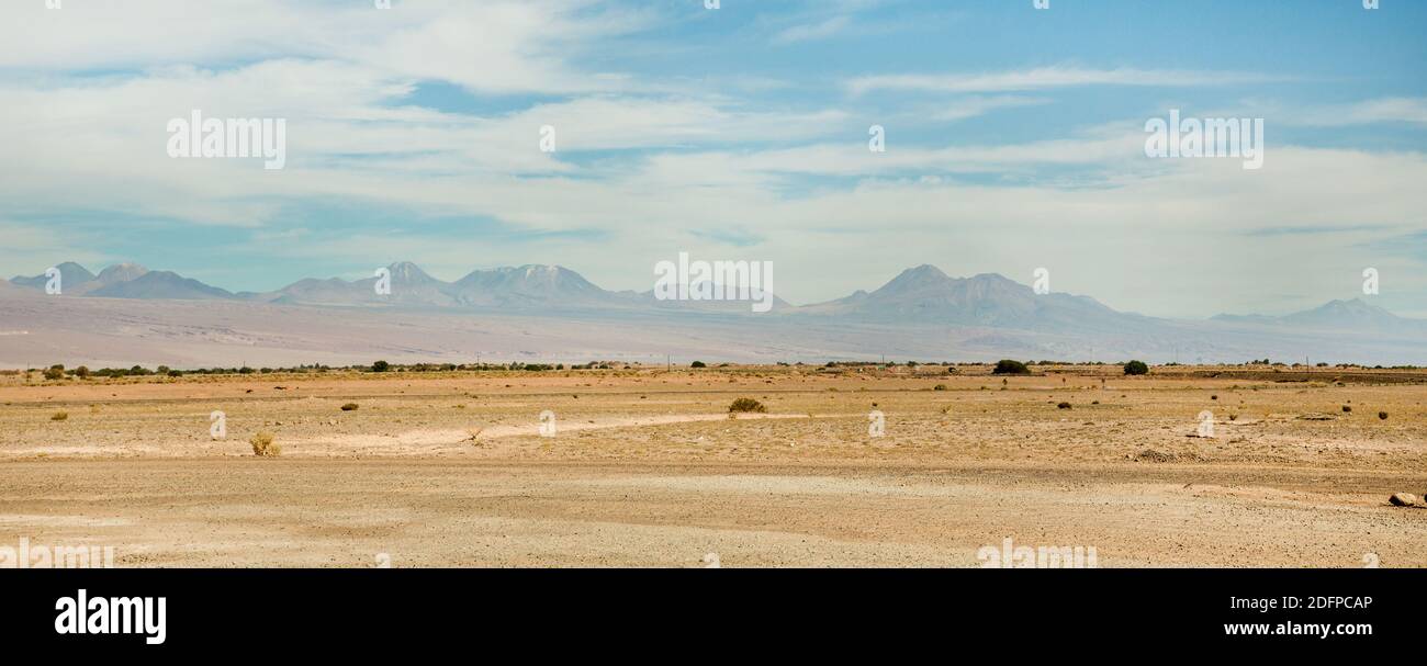 Volcanos in the Andes rise above the dry plains of the Atacama Desert ...