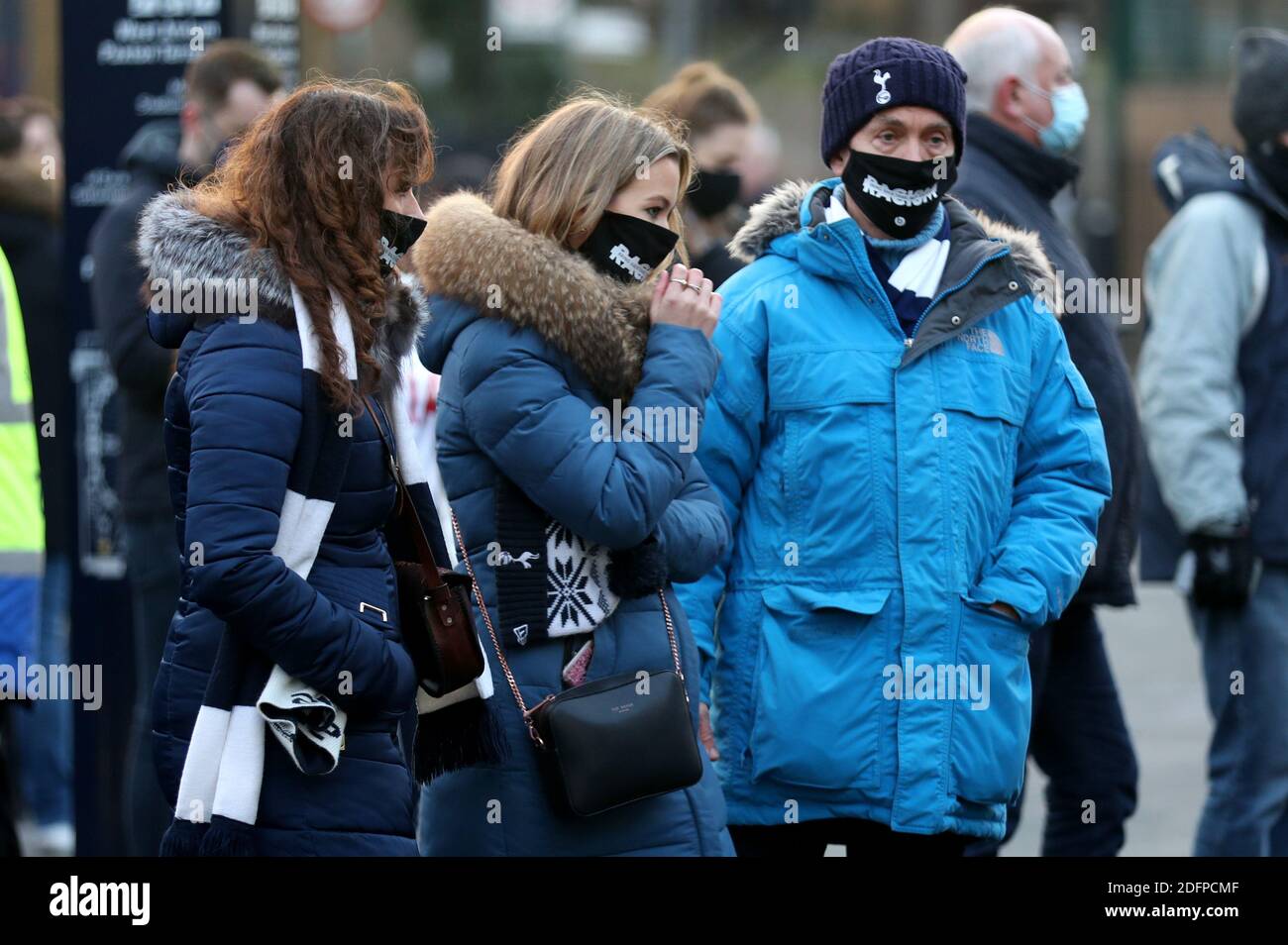 Tottenham Hotspur fans wearing face masks as they wait to enter the ...