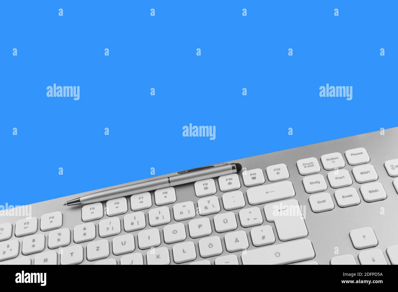 PC keyboard and pen against blue background Stock Photo - Alamy