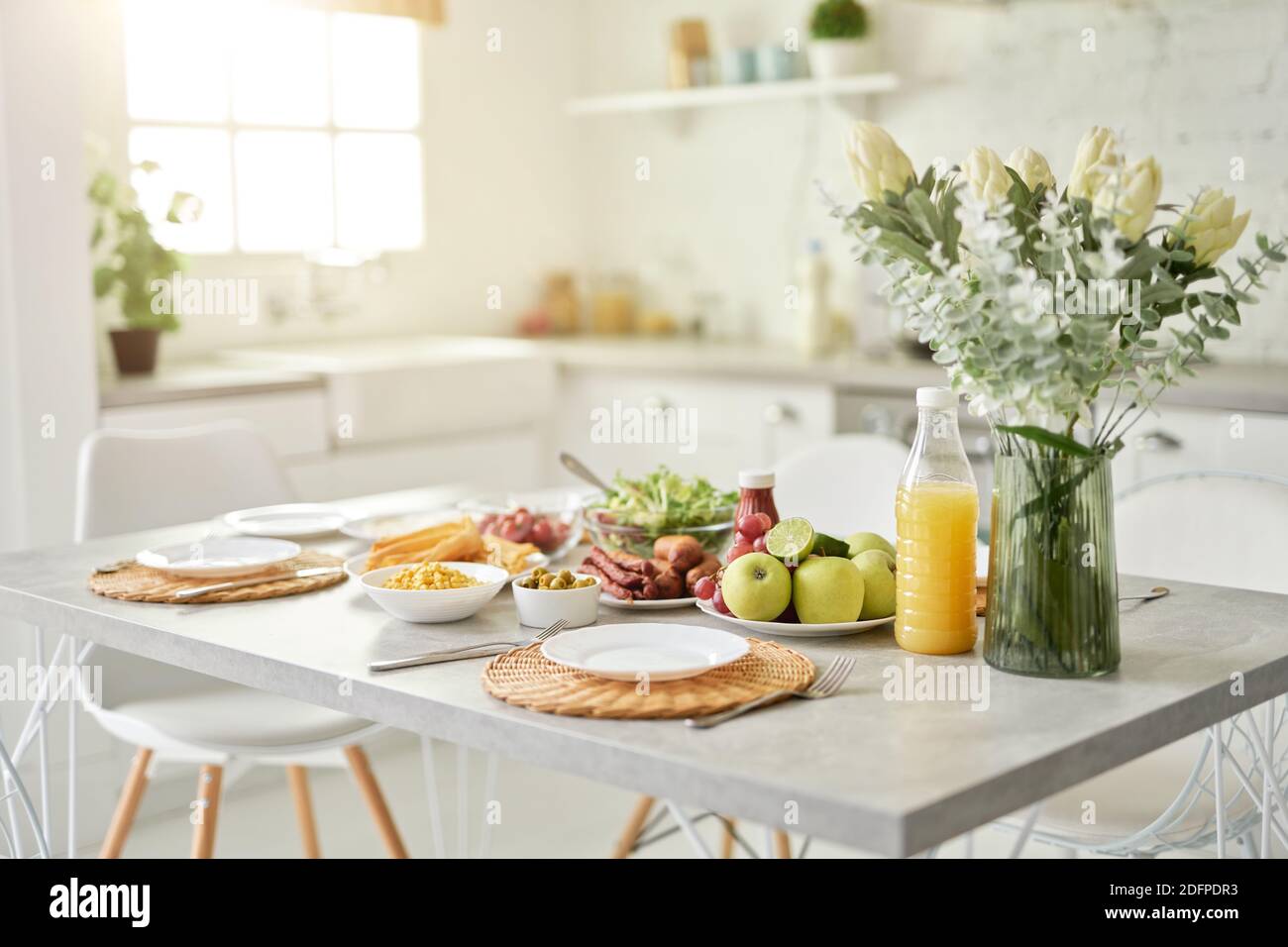 Close up of vase with flowers and Latin style breakfast on the kitchen ...