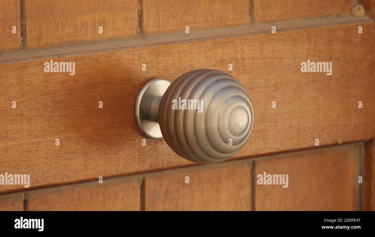 A metallic round door handle on a wooden door Stock Photo - Alamy
