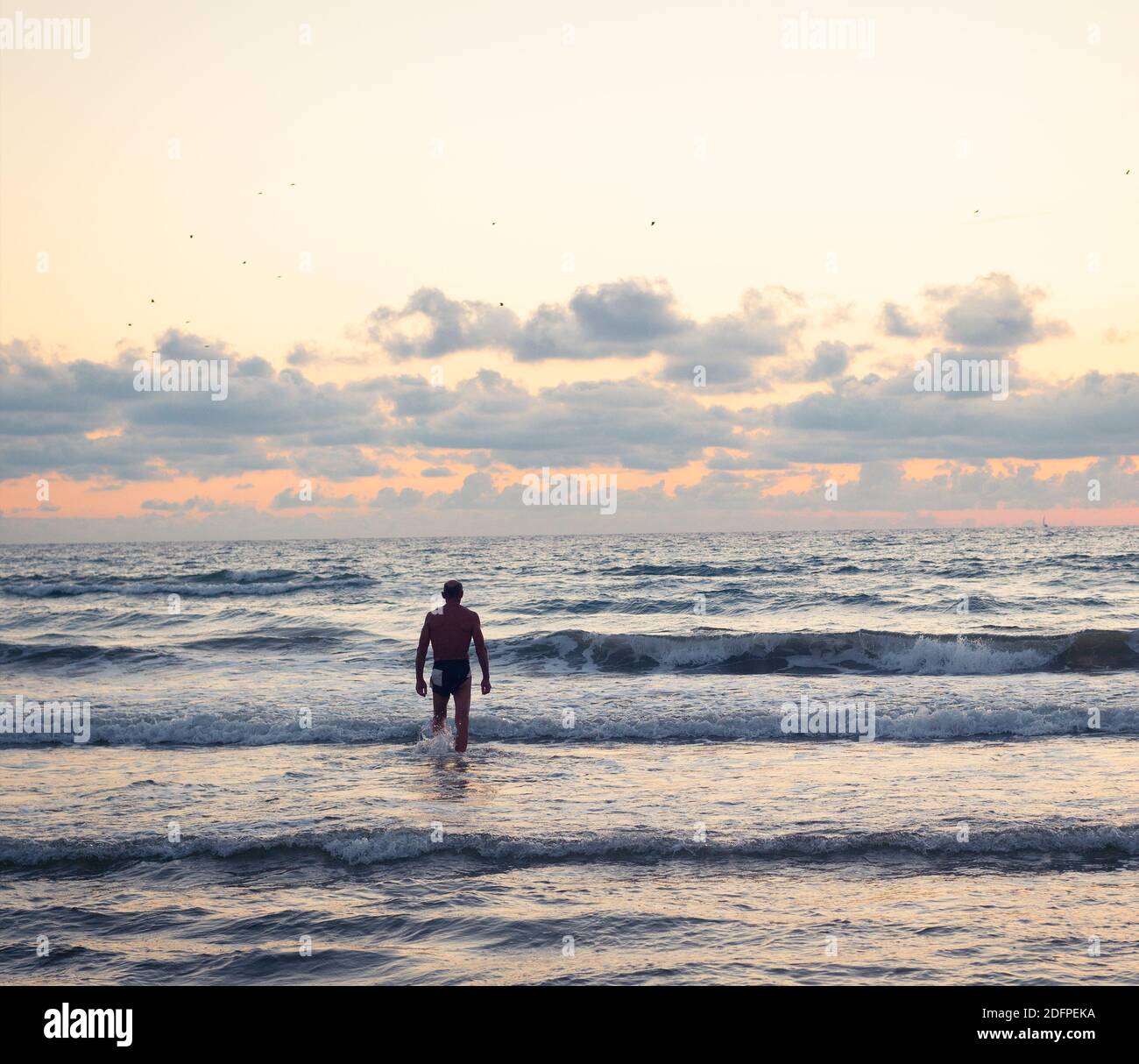 man on sunset sea beach Stock Photo - Alamy