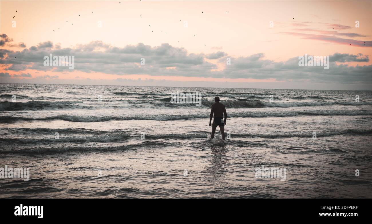 man on sunset sea beach Stock Photo - Alamy