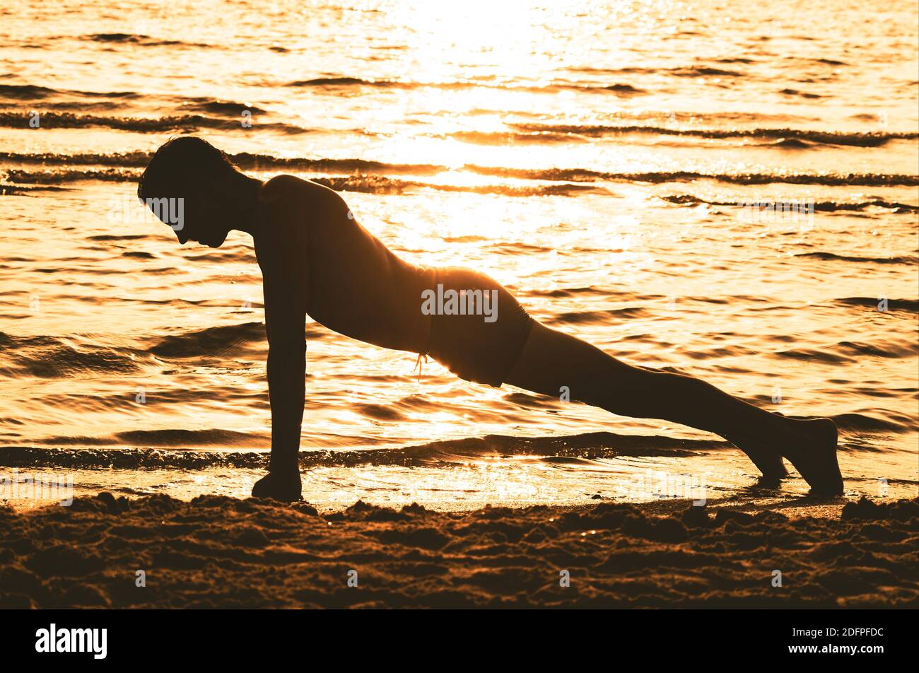 plank exercise on sunset beach Stock Photo - Alamy