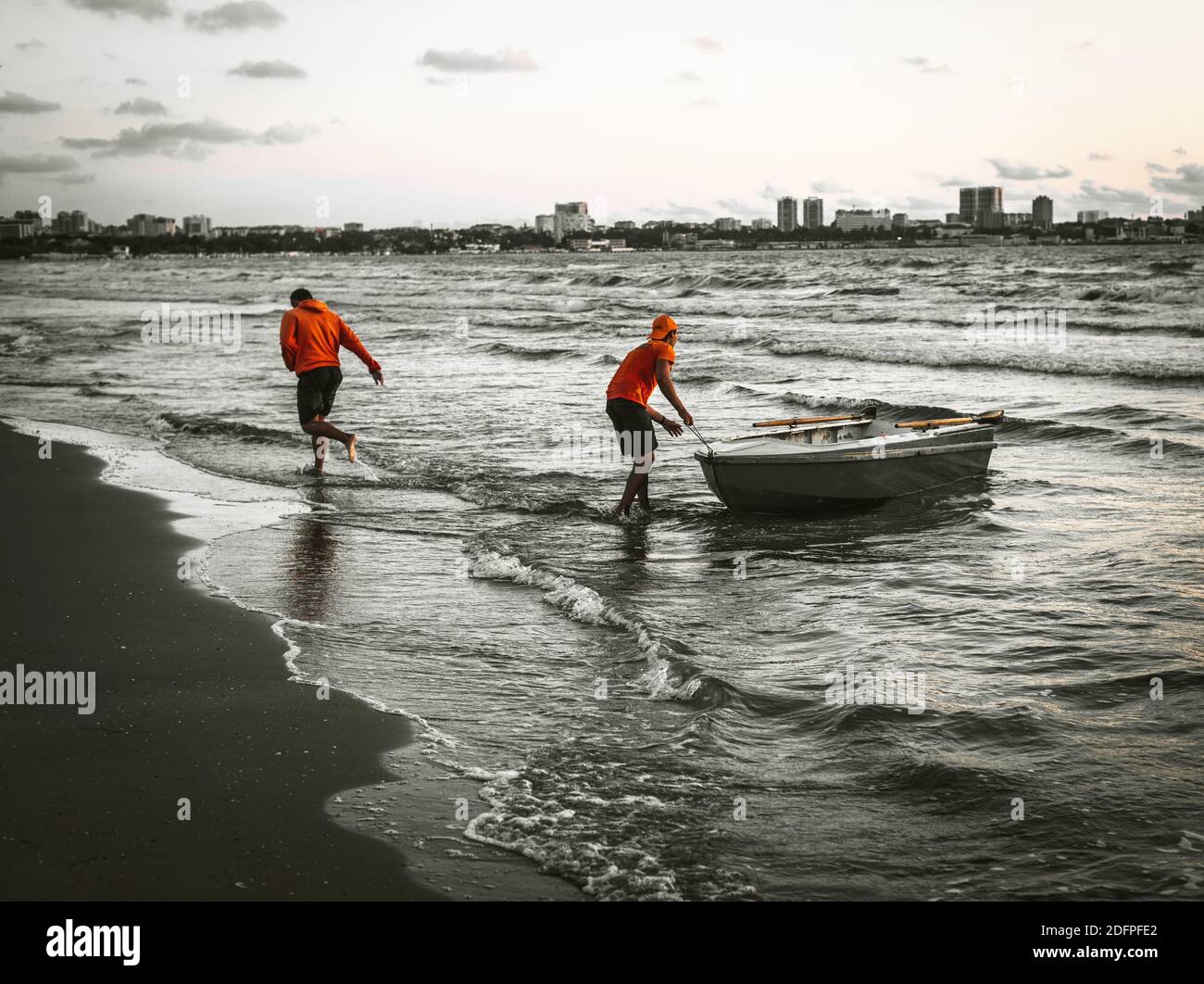 beach lifeguards with a rowing boat in stormy surf at evening Stock ...