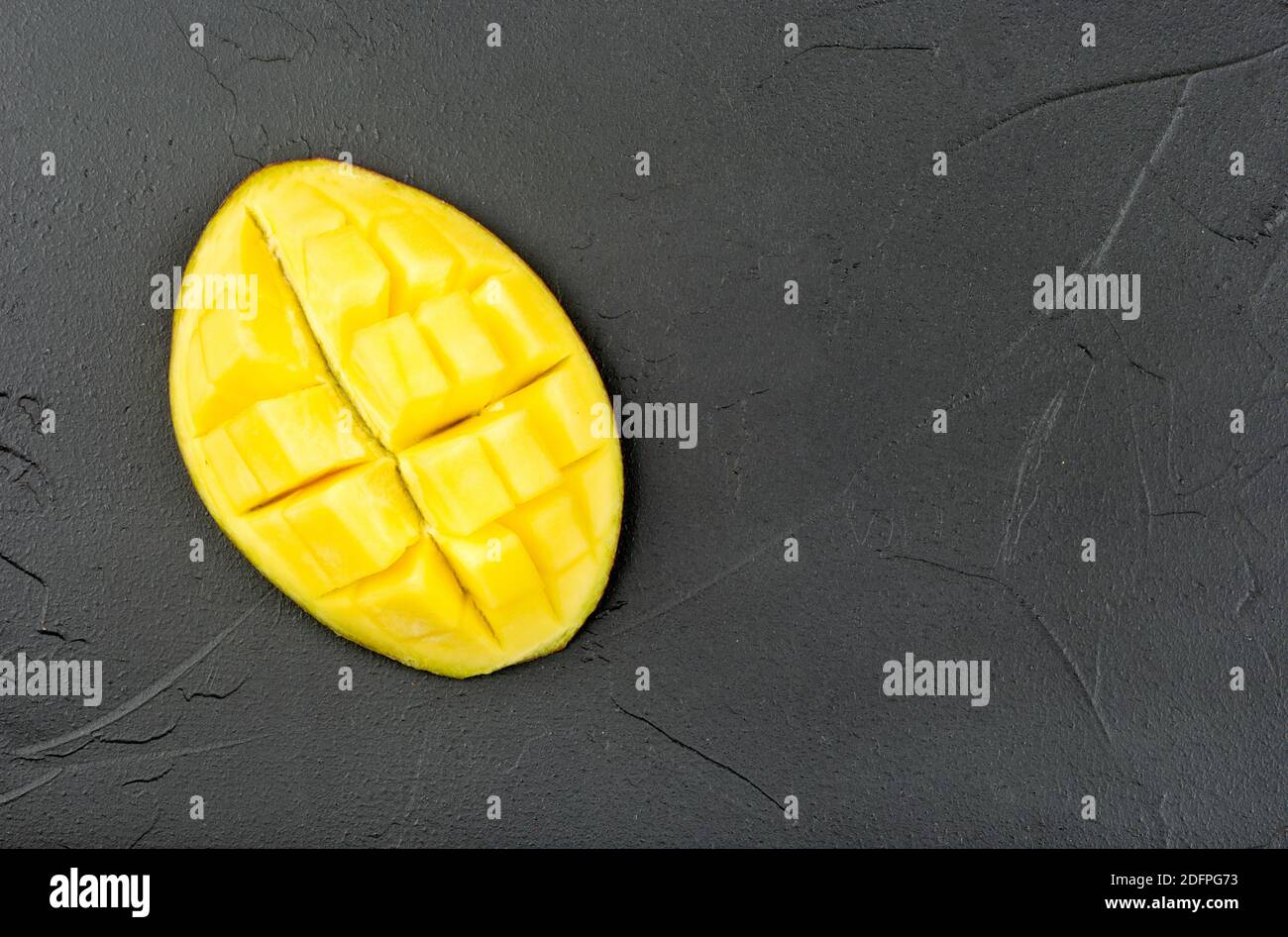 Juicy half of a ripe mango on a dark concrete background, top view ...
