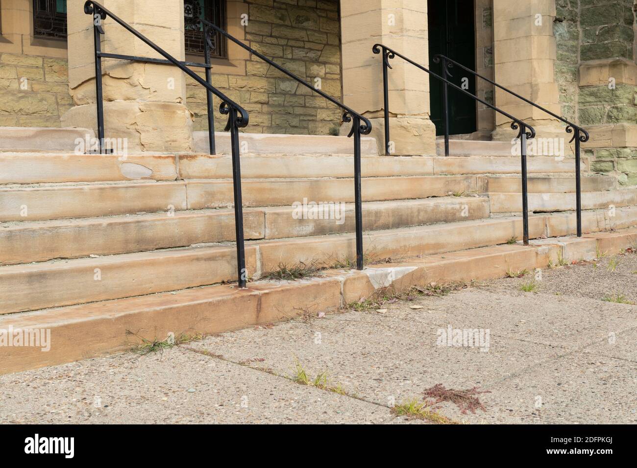 Decaying limestone stairs and columns of an old church entry, black ...
