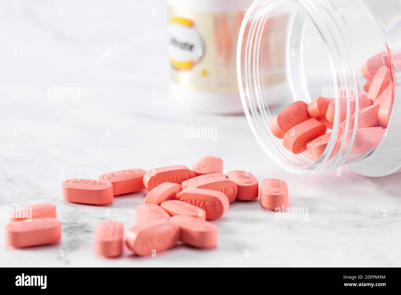 Pink medical pills of Caltrate with a transparent bottle isolated on a ...