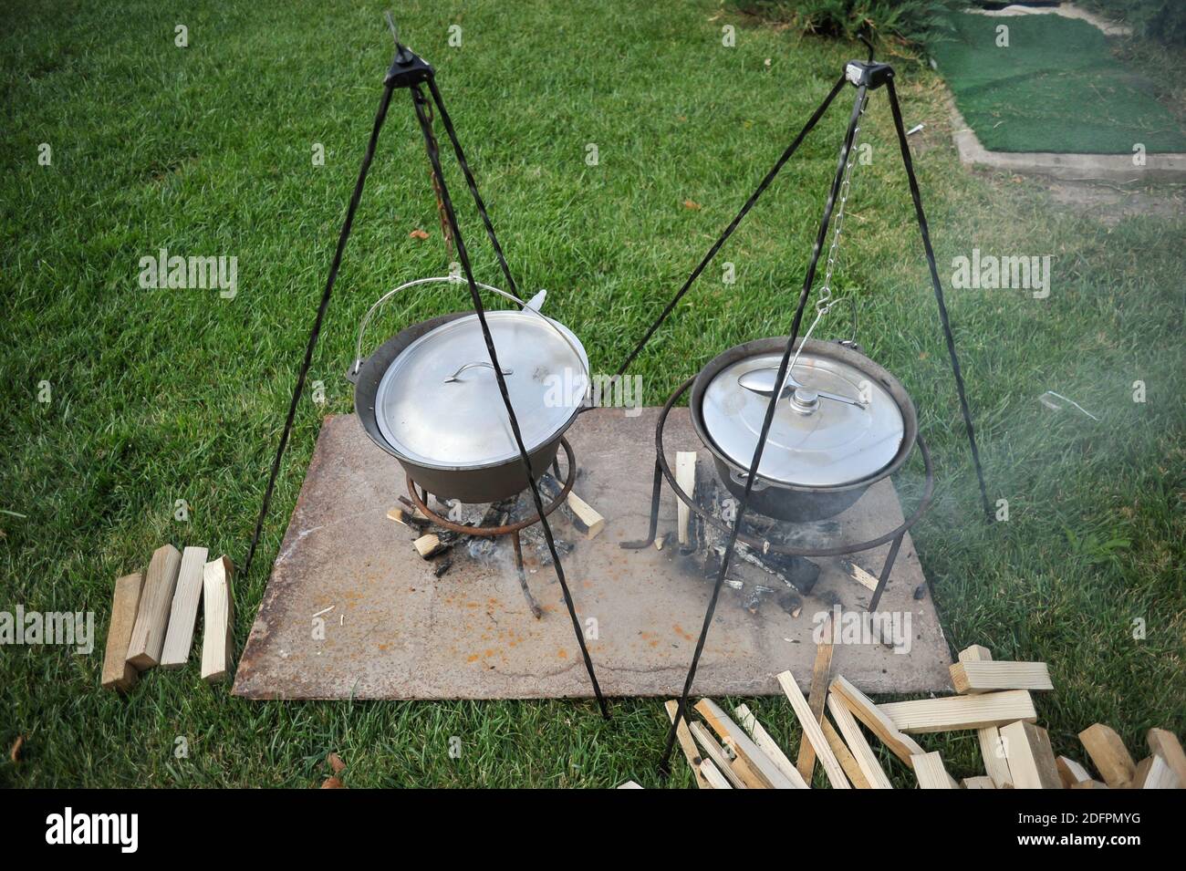 Details with cast iron cauldrons and firewood prepared for an outdoor ...