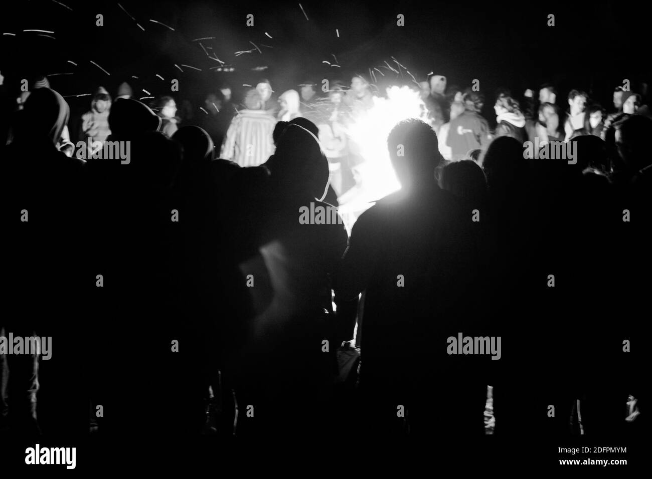 Moody and atmospheric image with people silhouetted against a fire on ...