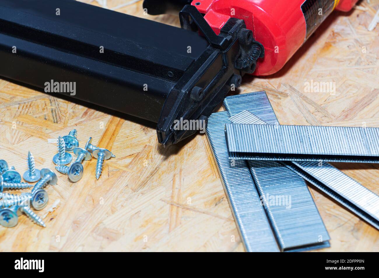 Red pneumatic construction stapler and a stack of staples for the ...