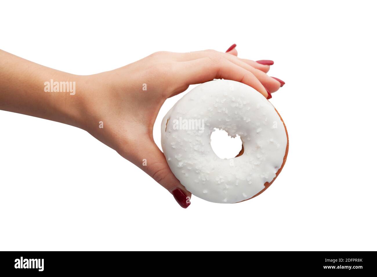 Female hand holds with fingers a donut in sugar glaze isolated on white ...