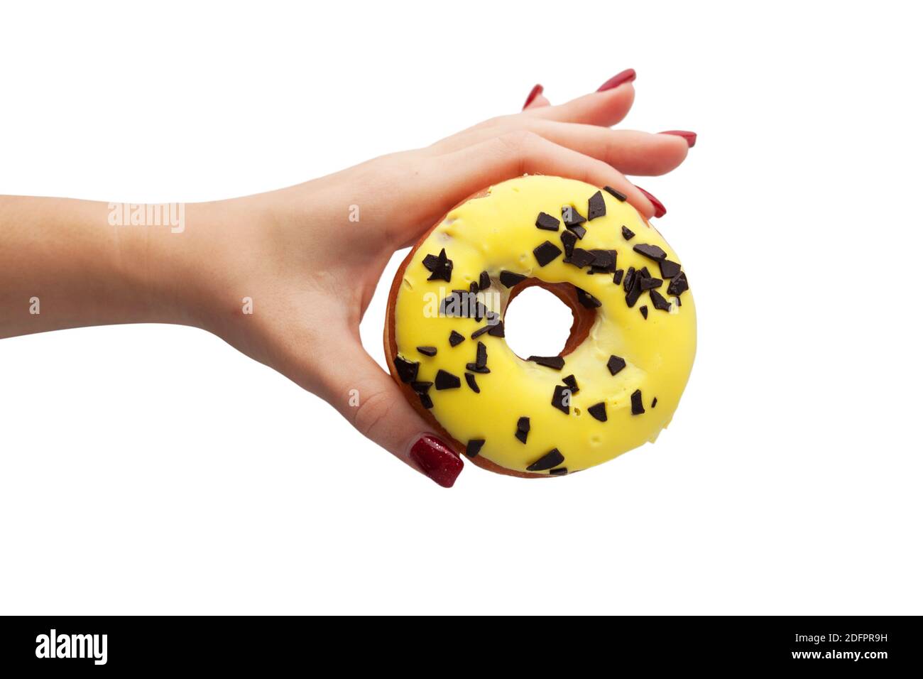 Female hand holds with fingers a donut in yellow glaze isolated on ...