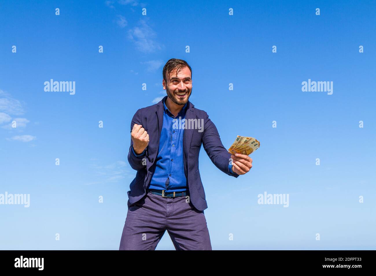 Cheerful attractive bearded young man holding 50 euro banknotes smiling ...