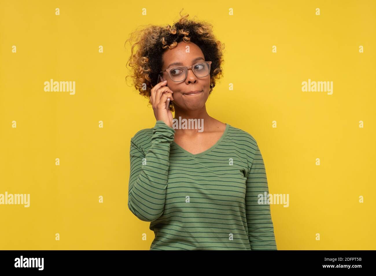Young african woman talking on phone with her friend. Studio shot on ...