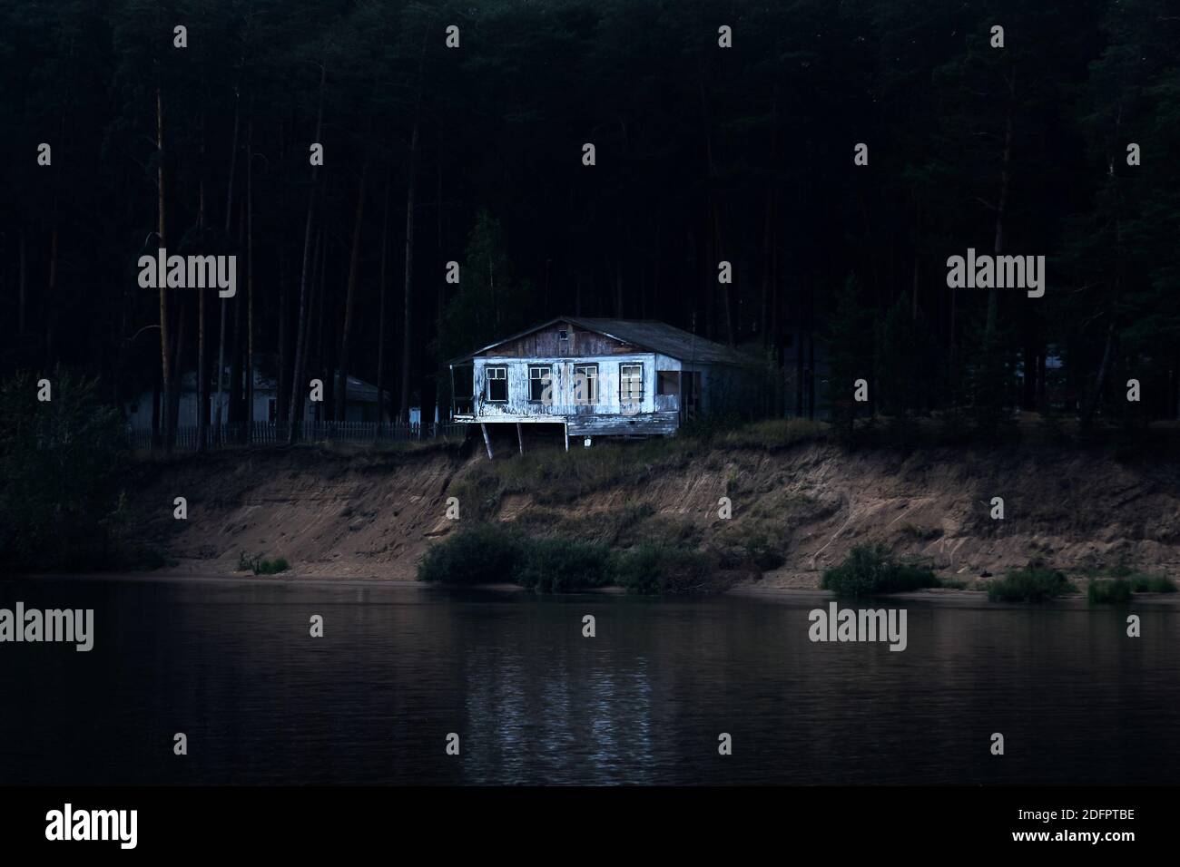 abandoned dilapidated house on a dark wooded bank is ready to collapse ...