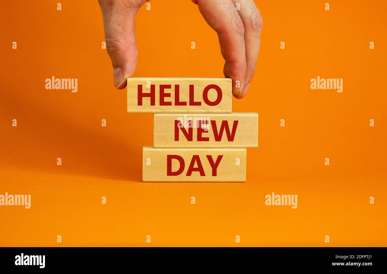 Hello new day symbol. Male hand. Wooden blocks tower with words 'hello ...