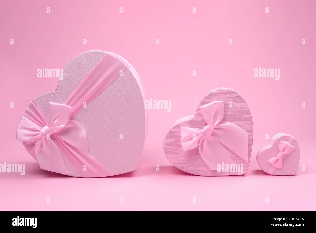 Pink heart-shaped gift with bow for Valentine's Day on a pink ...