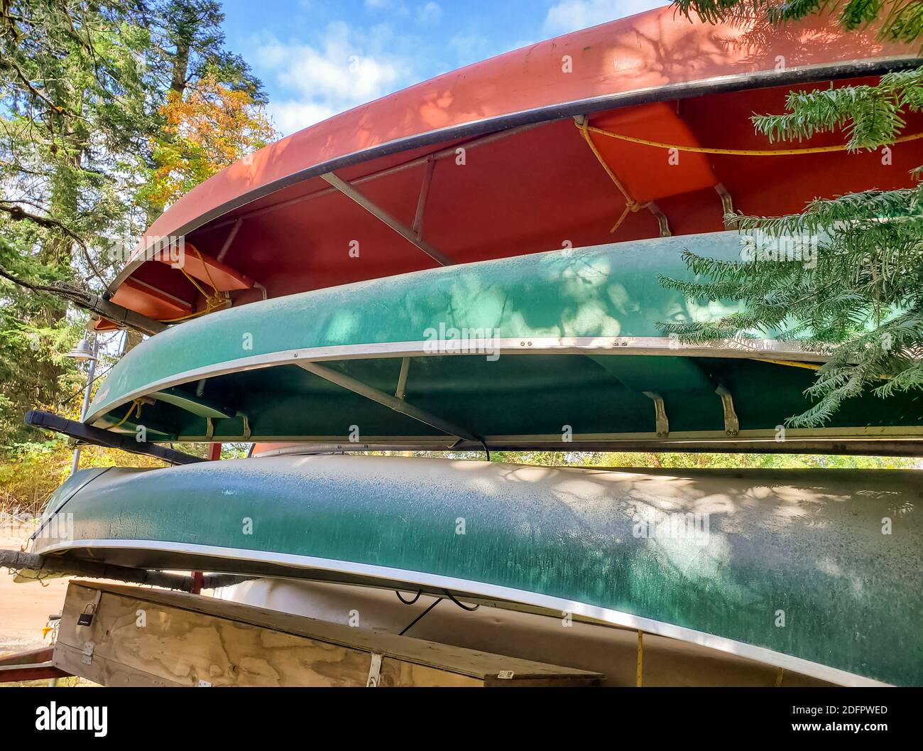 Inverted colorful canoes boats on shore.Stacked together on the beach ...