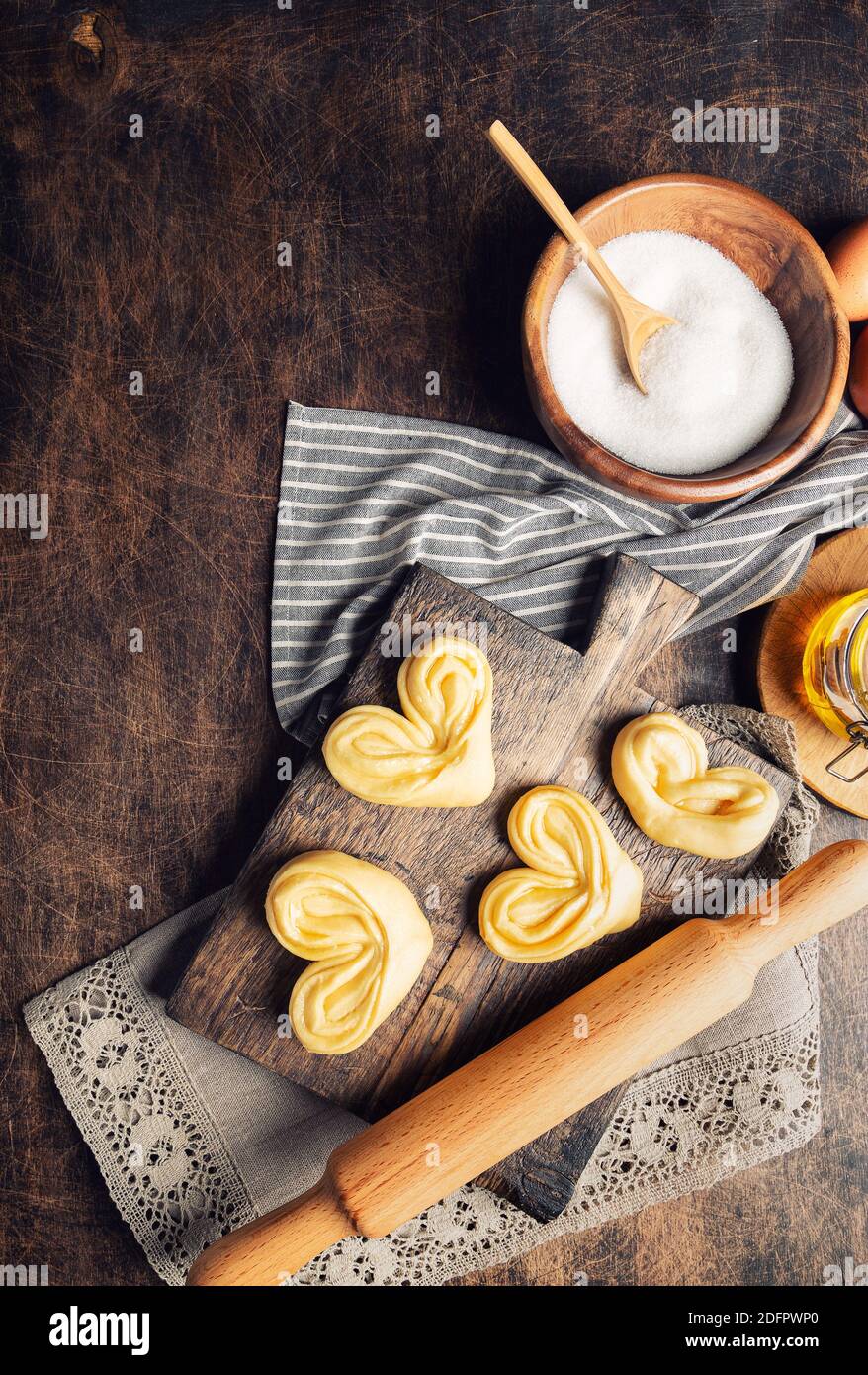 Raw unbaked homemade sweet buns with honey and sugar on rustic plywood ...