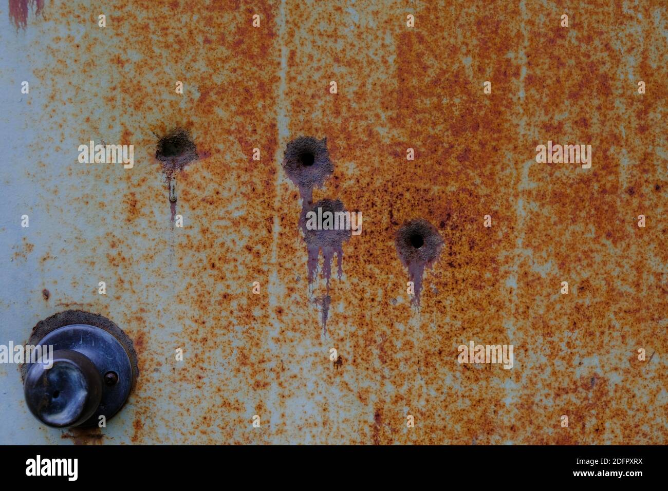 bullet holes in a metal door on an abandoned building Stock Photo - Alamy