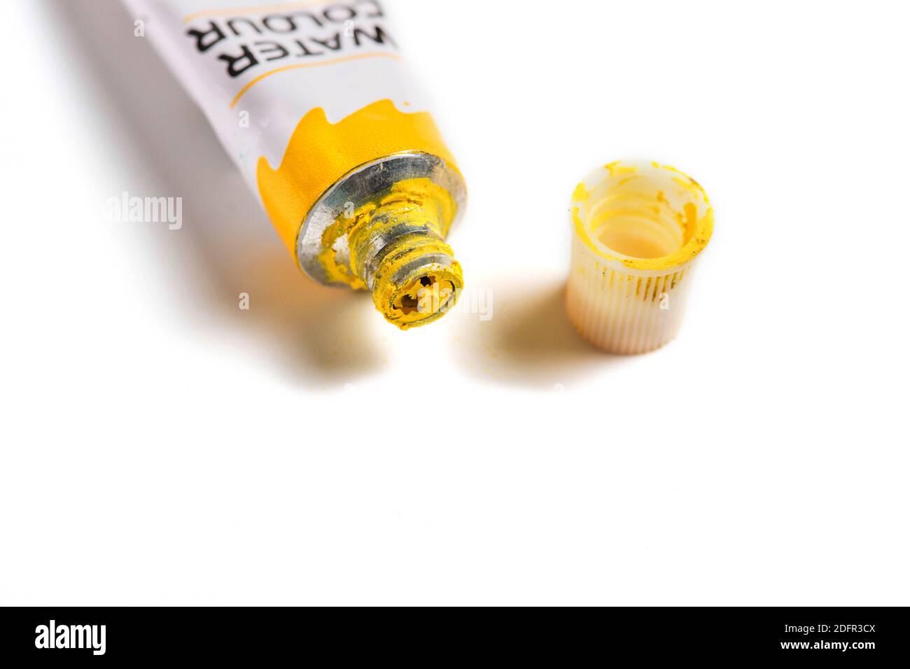 Dried yellow watercolor paint in a tube isolated on white background ...