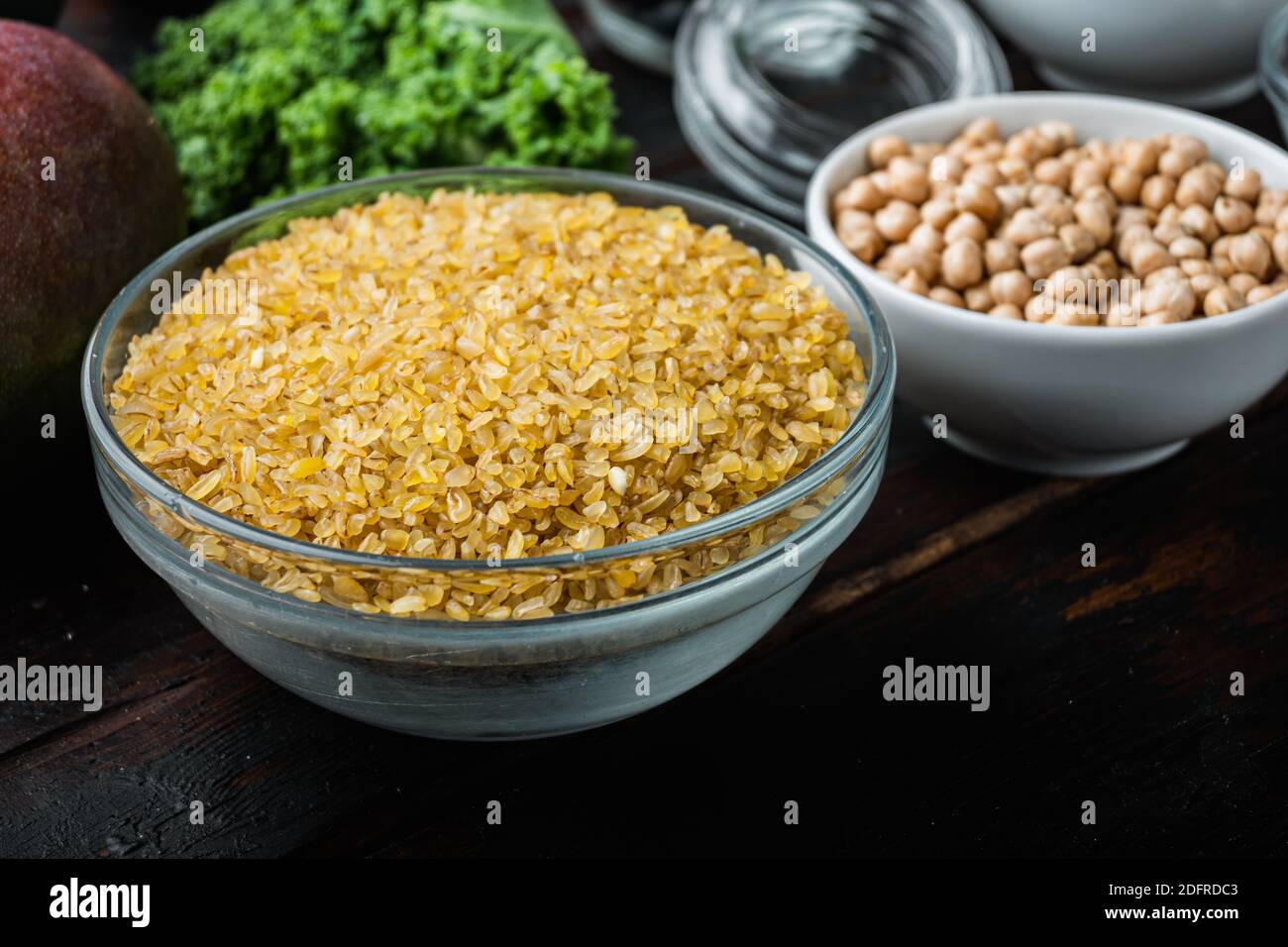 Bulgur grain in bowl on dark wooden background Stock Photo - Alamy