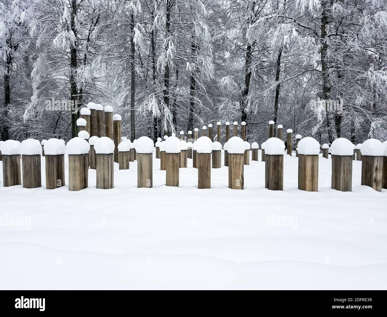 Winter landscape with a park in a wooded area with sculptures and trees ...