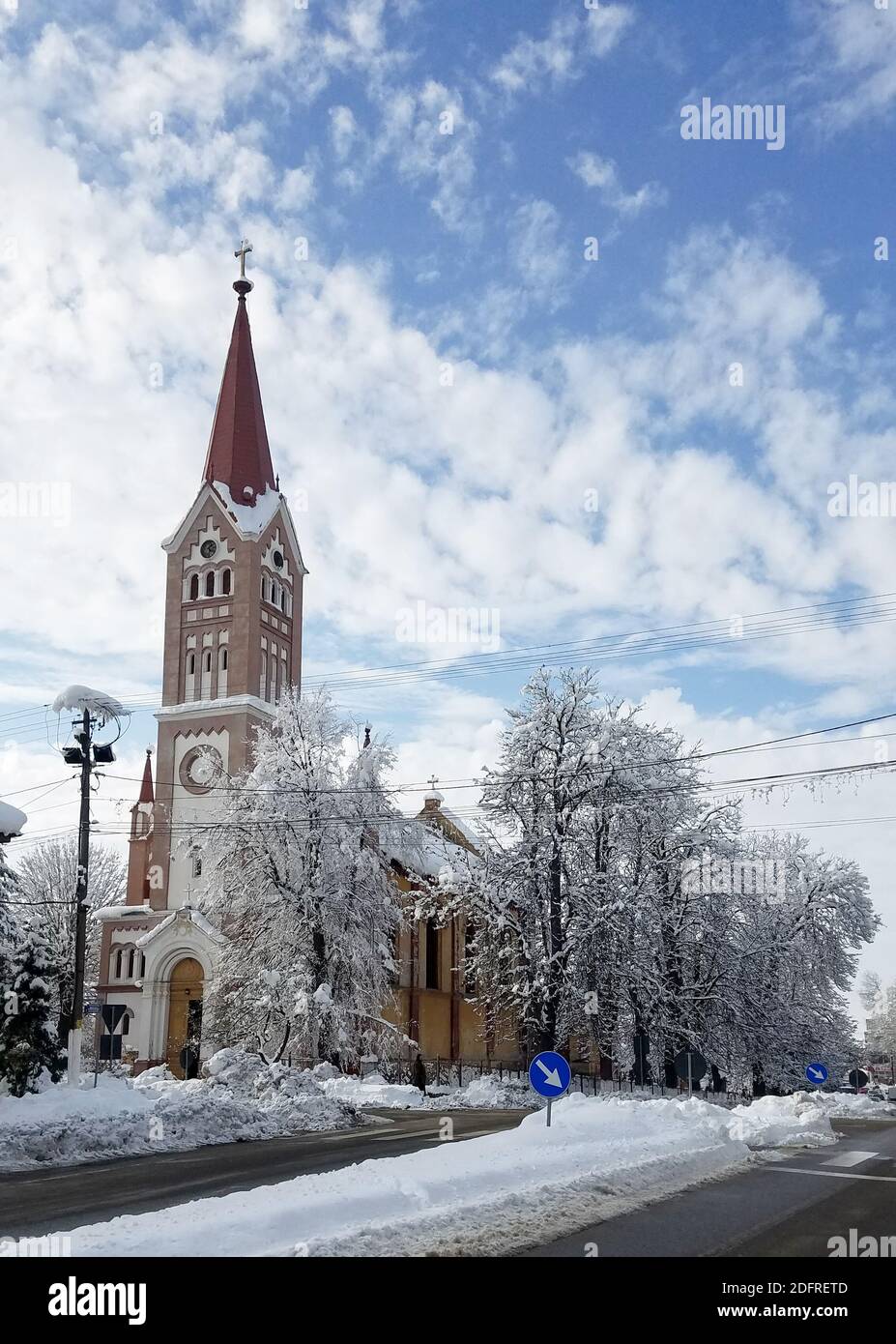 Holiday background with a Catholic church surrounded by snow covered ...
