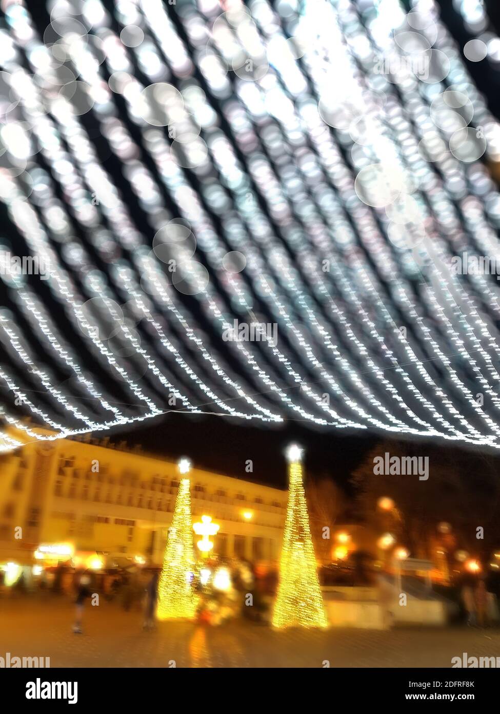 Bokeh background with outdoor Christmas lights decoration in the city ...